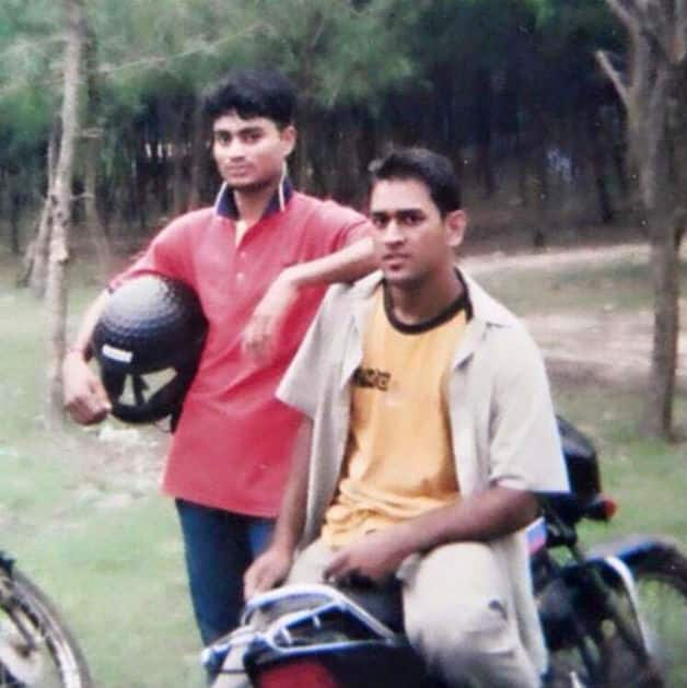Young MS Dhoni sitting on a bike with short hair - Cricket Country